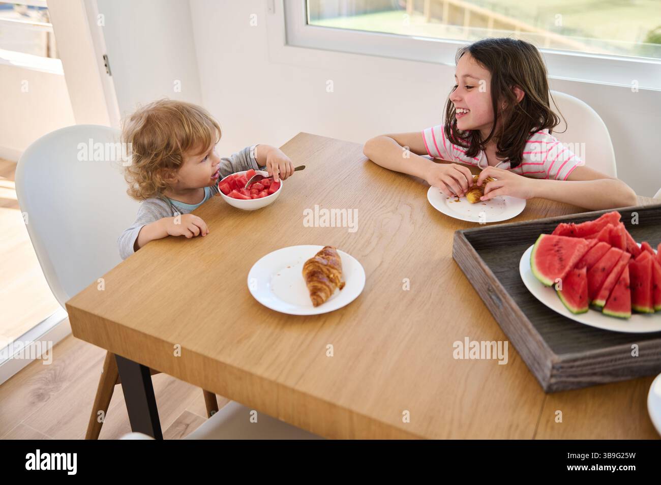 A bright dining room with children sharing a joyful breakfast ...