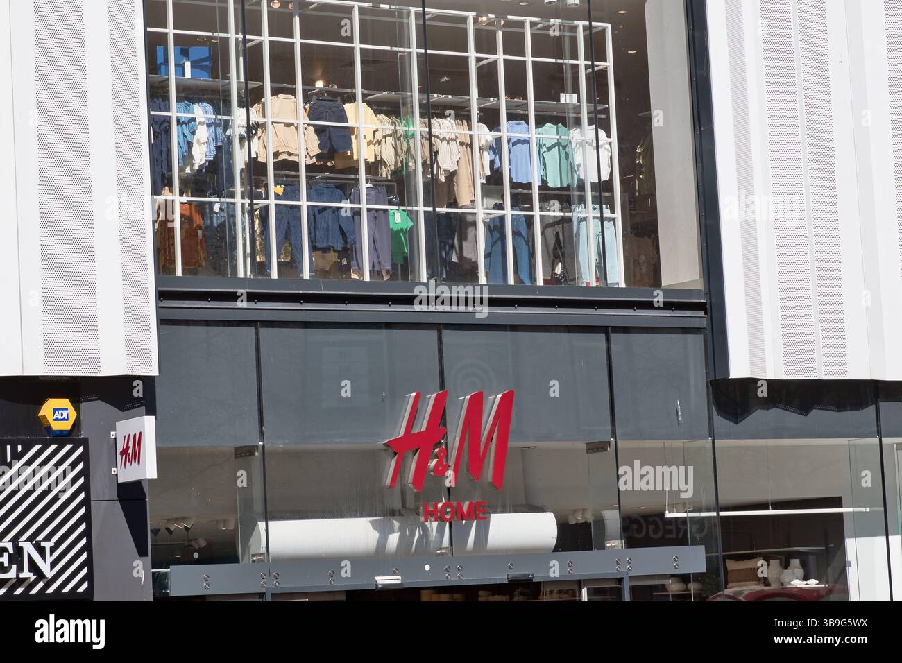 Exterior view of an H&M store front with clothing displayed in the ...