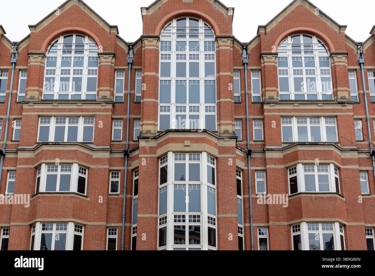 Facade of a brick building featuring multiple windows and symmetrical ...