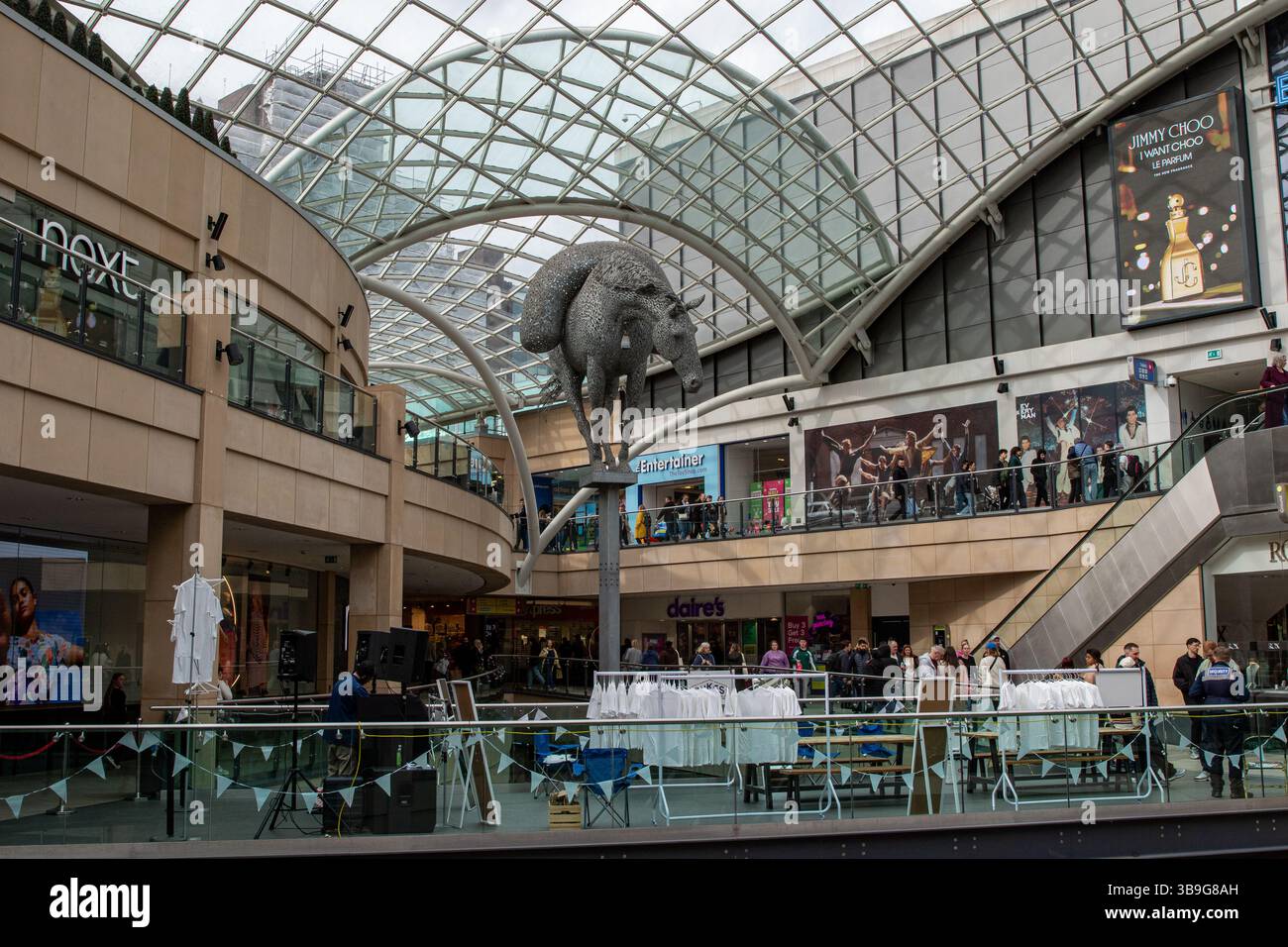 Interior view of a multi-level shopping mall with a metal horse ...