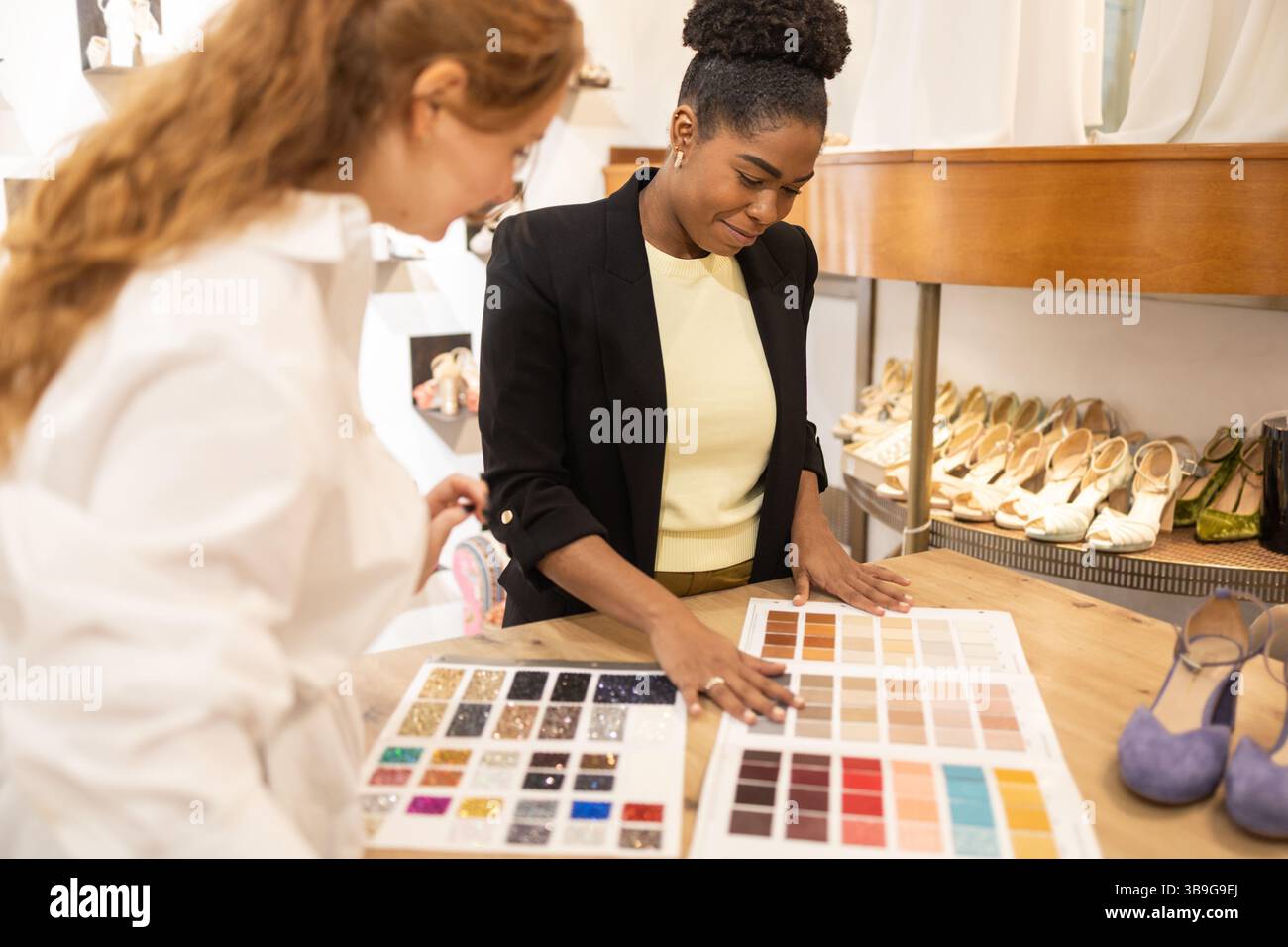 Two women engaged in a color selection task in a fashion boutique ...