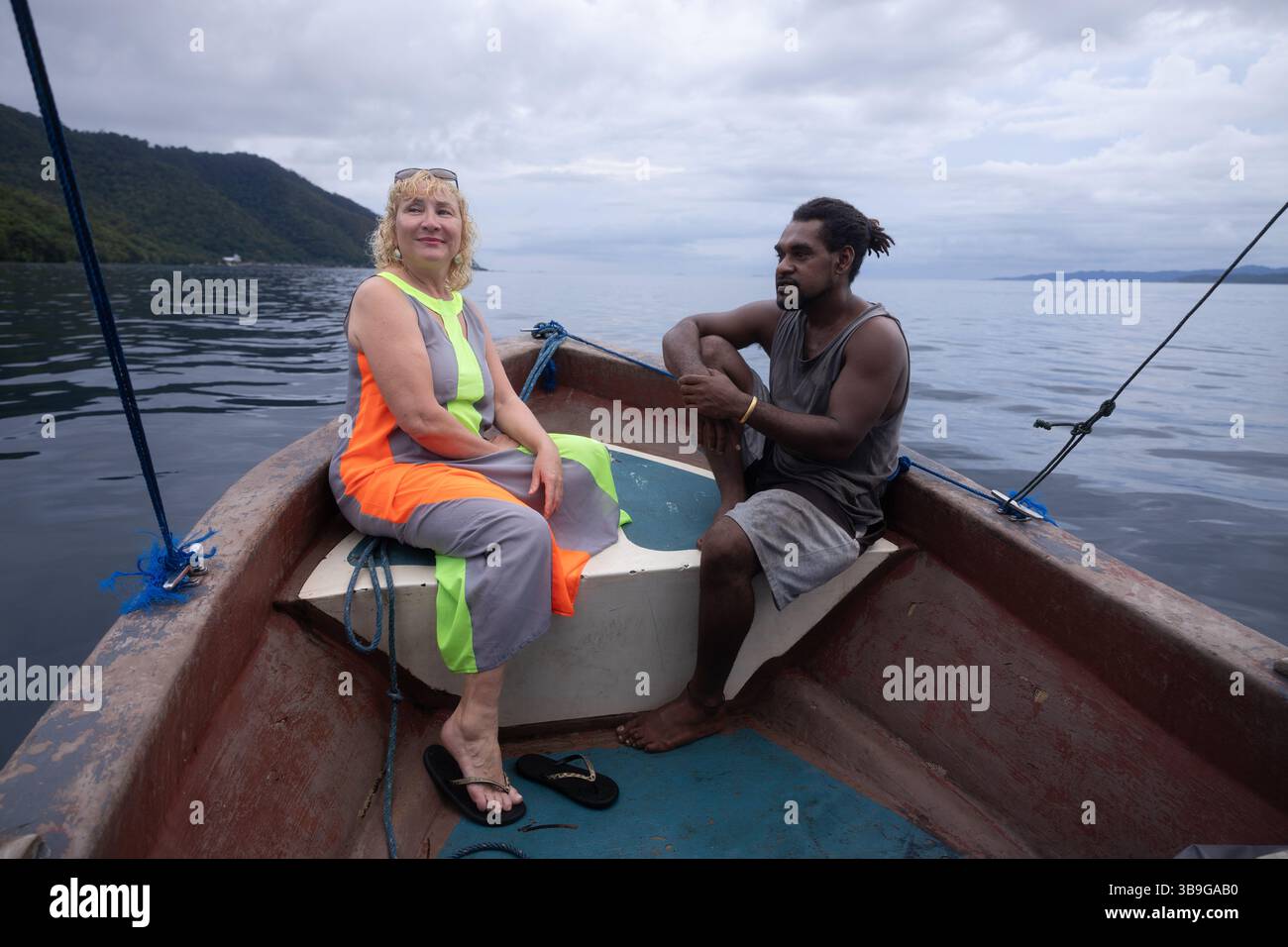 A mature female tourist and a native man share a scenic boat tour ...