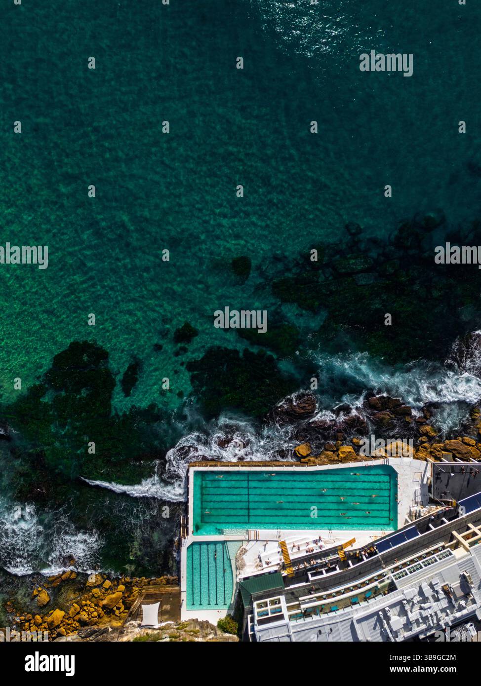 A stunning aerial view captures a seaside pool adjacent to the ocean in ...