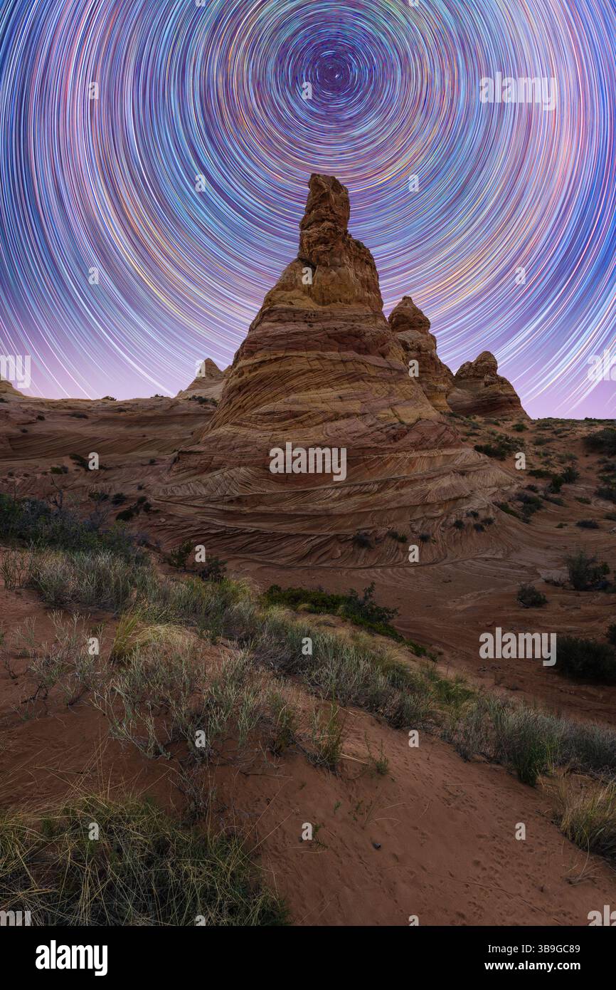Stunning star trails swirl above a striking desert rock formation ...
