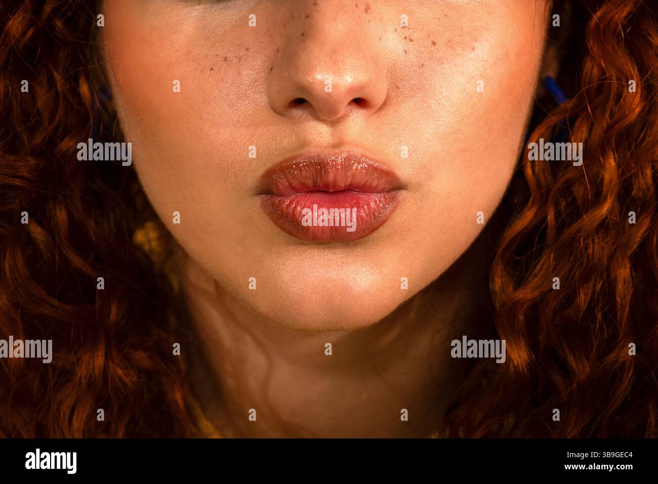 A close-up image captures a woman's glossy lips, slightly pouted ...