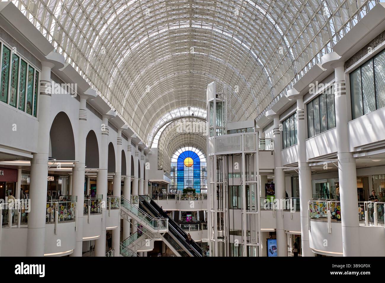 Interior view of a multi-story shopping mall with a vaulted glass ...