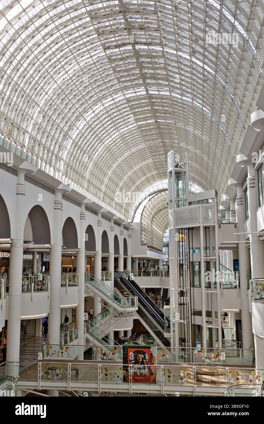 Interior view of a multi-story shopping mall with a large arched glass ...