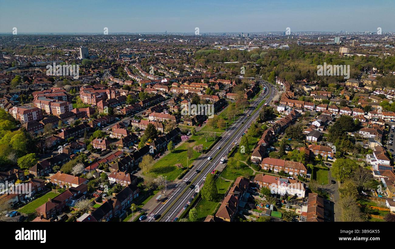 Aerial view of a suburban landscape featuring houses, a road, and green ...
