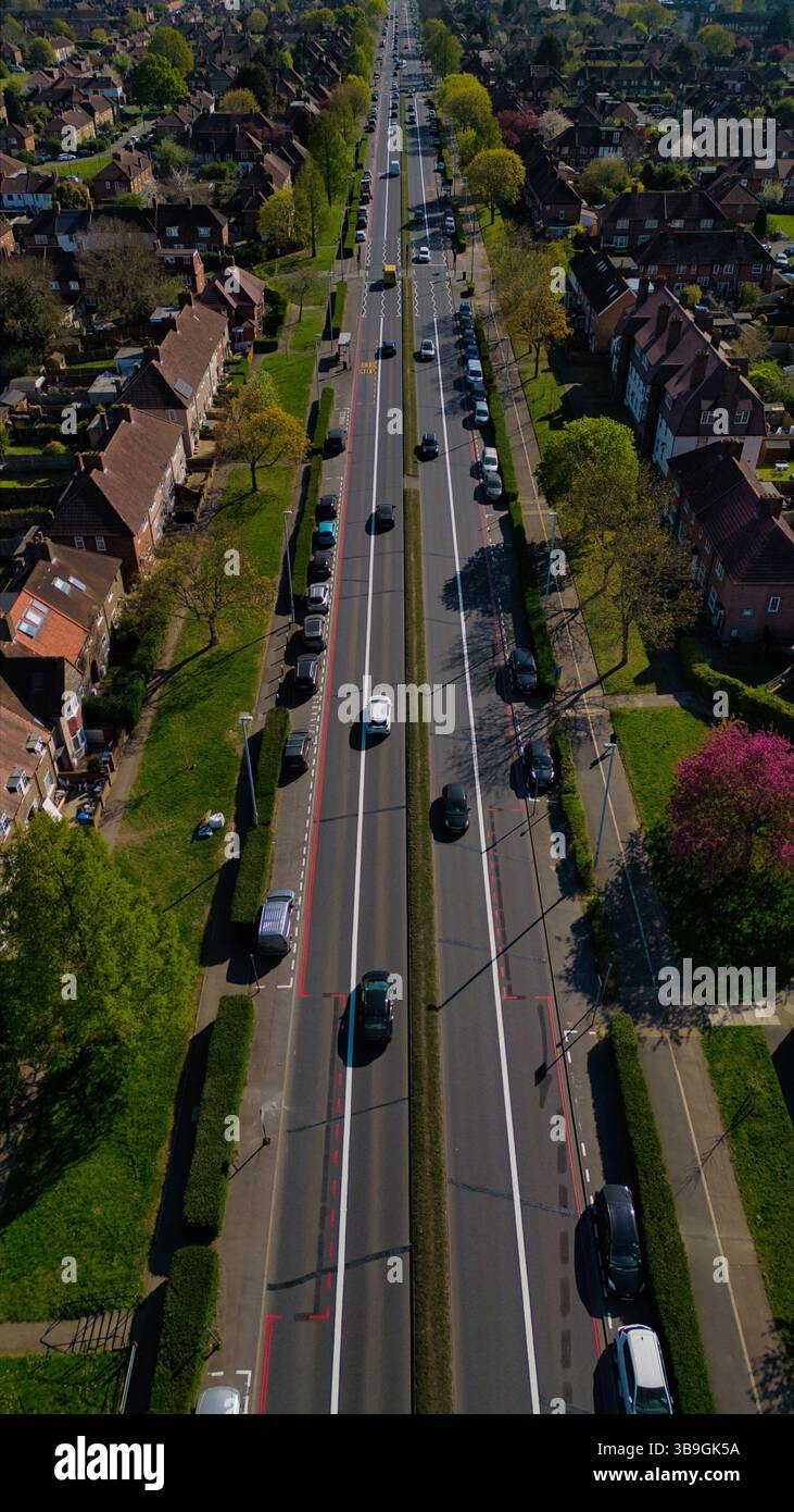 Aerial view of a straight road dividing residential area, lined with ...