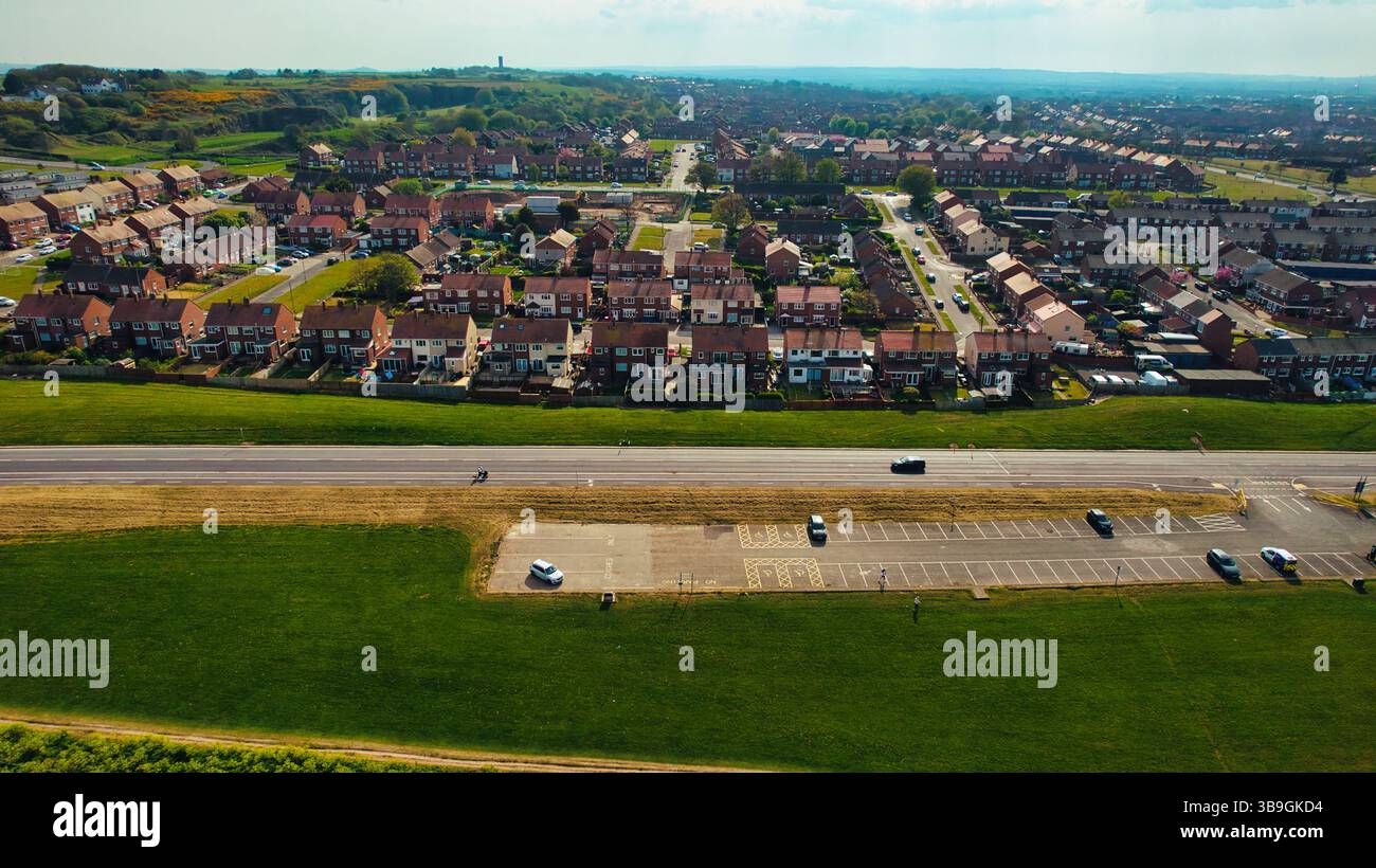 Aerial view of a suburban neighborhood with a road, parking lot, and ...