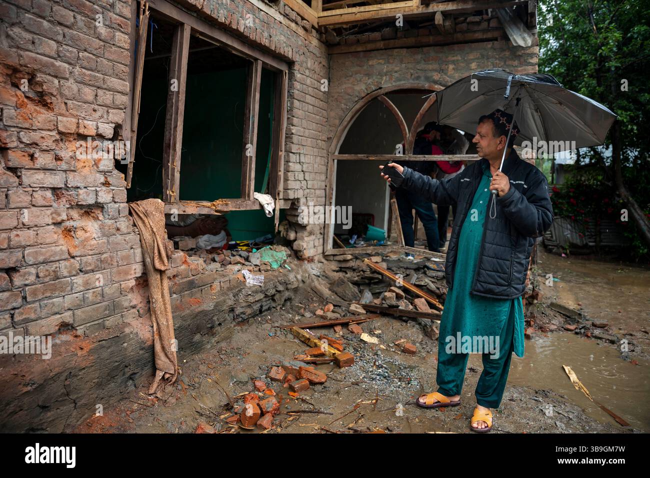 An Indian villager points at a house damaged by Pakistani shelling in ...