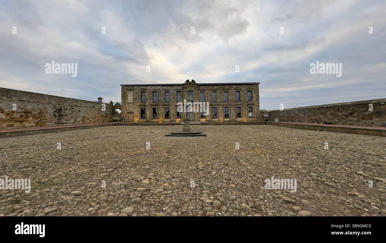 Building facade, cobblestone courtyard with statue. Stone walls on ...