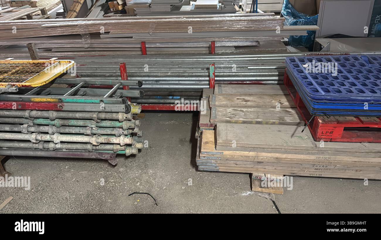 Image shows stacked construction materials, including scaffolding ...