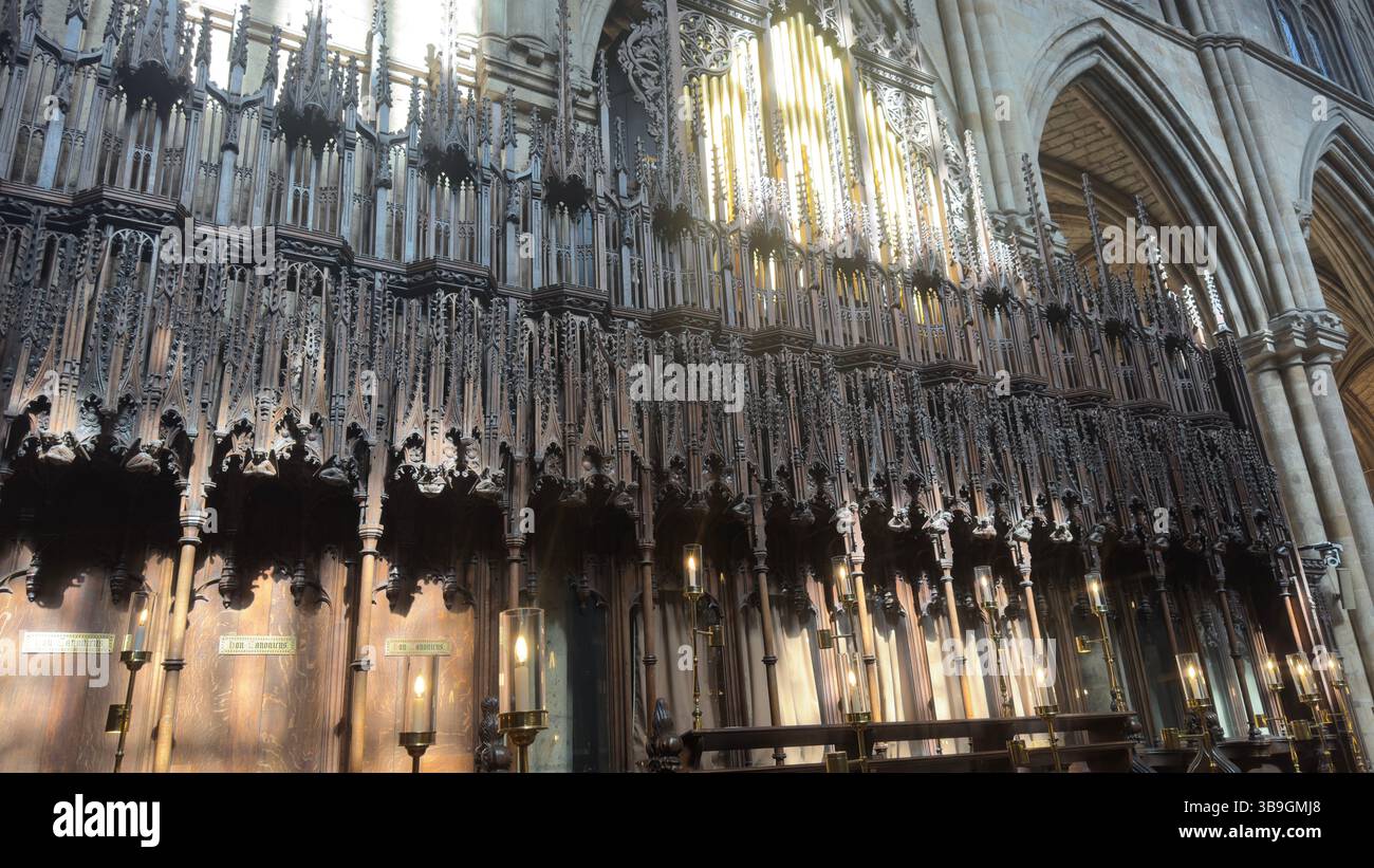 Interior view of dark wood choir stalls in a cathedral, featuring ...