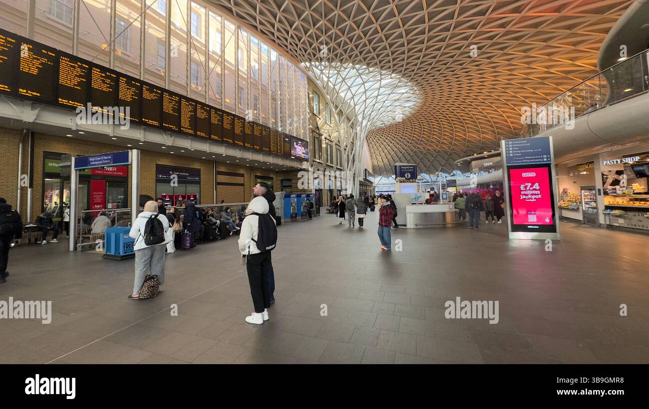 Interior view of King's Cross Station, London, featuring people, shops ...