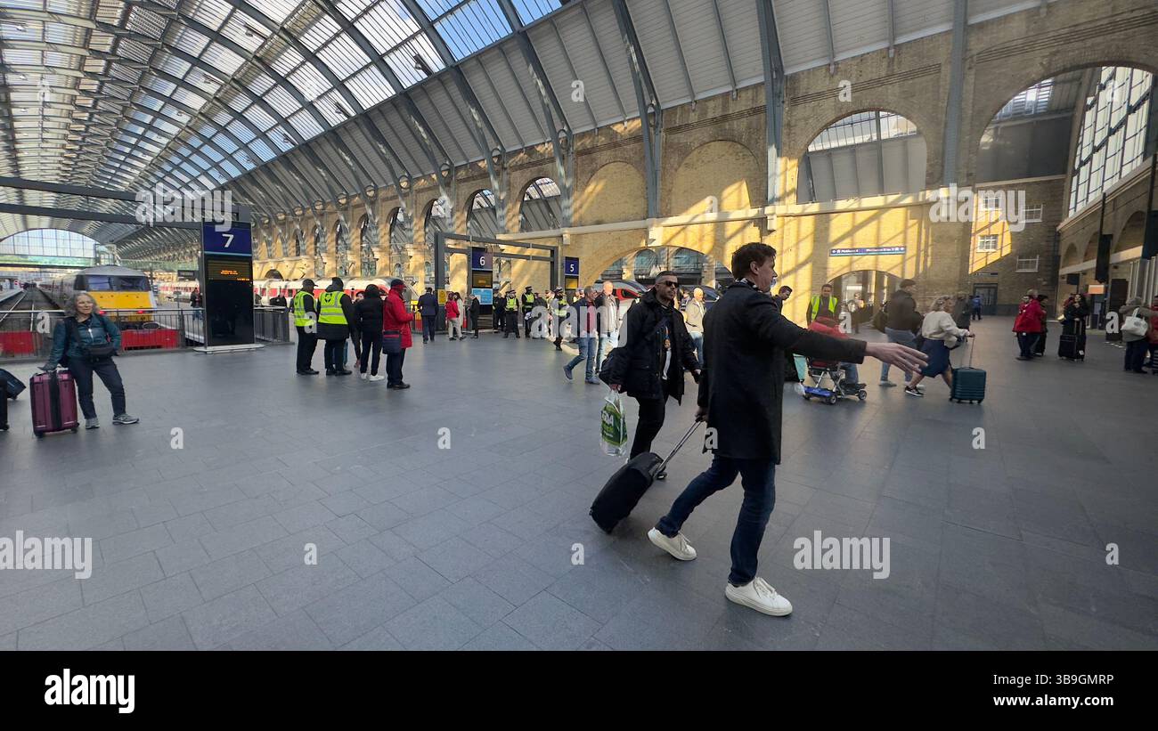 Interior of a train station with passengers, tracks, and overhead ...