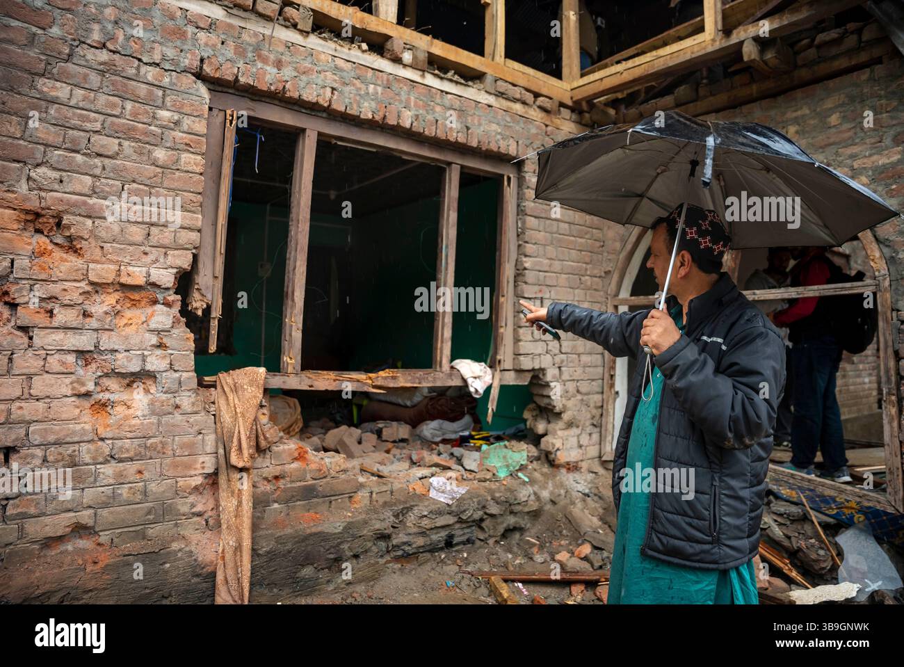 An Indian villager points at a house damaged by Pakistani shelling in ...