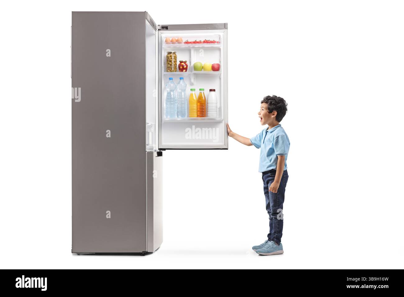 Full length profile shot of a boy opening a fridge isolated on white ...