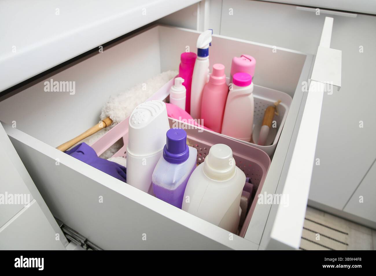 Drawer with cleaning supplies and baskets in modern kitchen Stock Photo ...