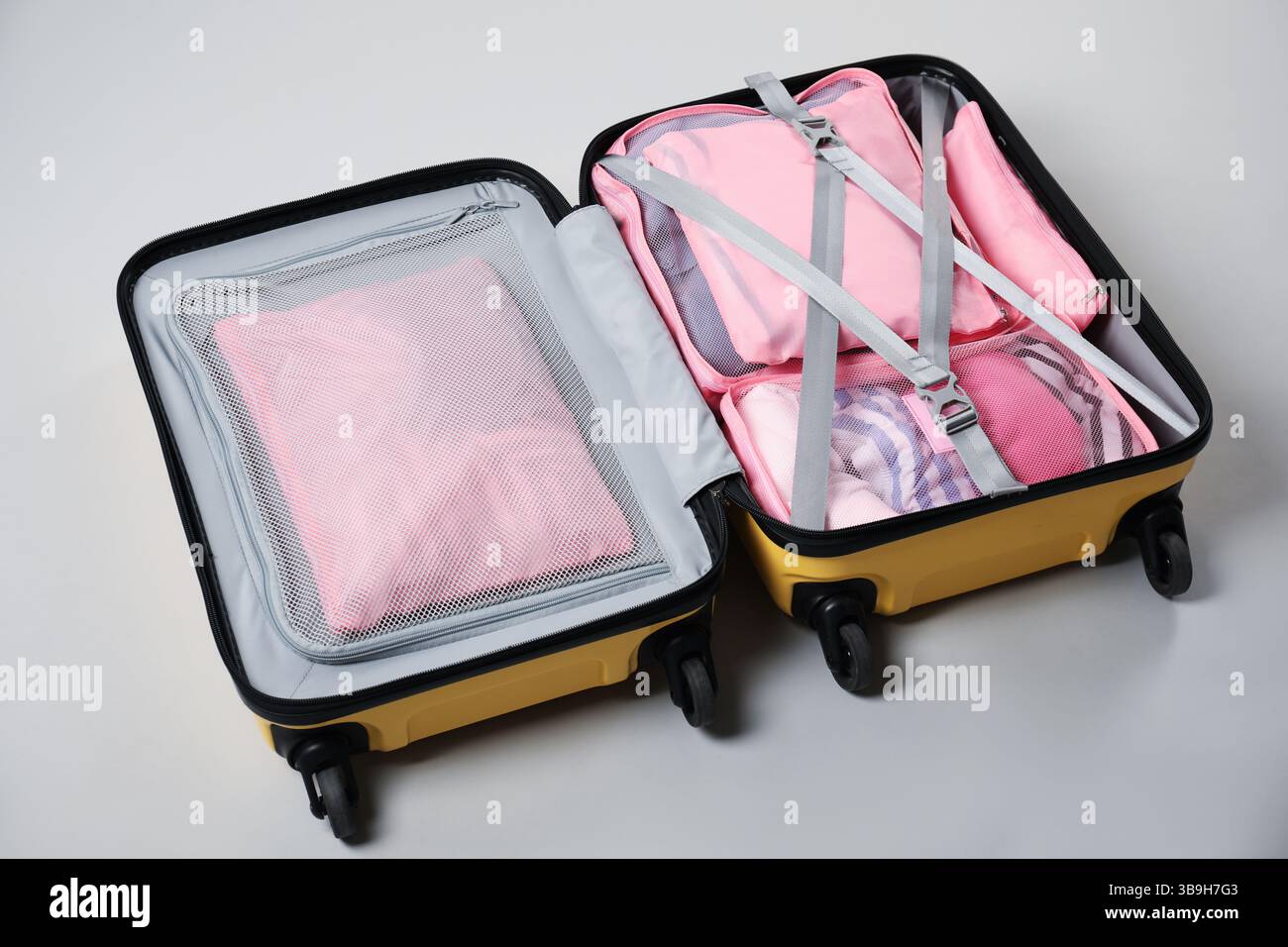 Open suitcase with packing cubes on light grey background, above view ...