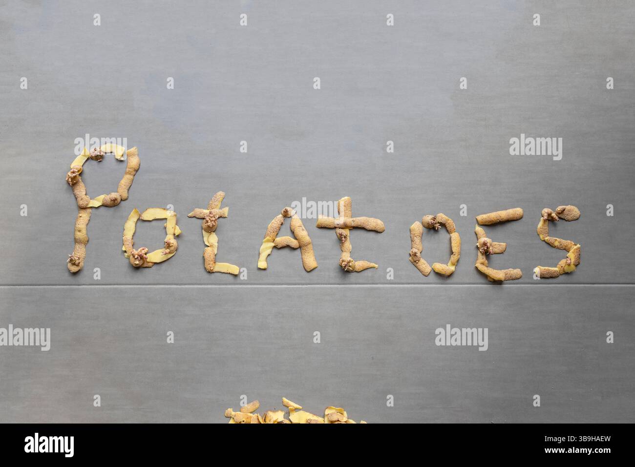 The English word potato is in the form of peels on a gray background on ...