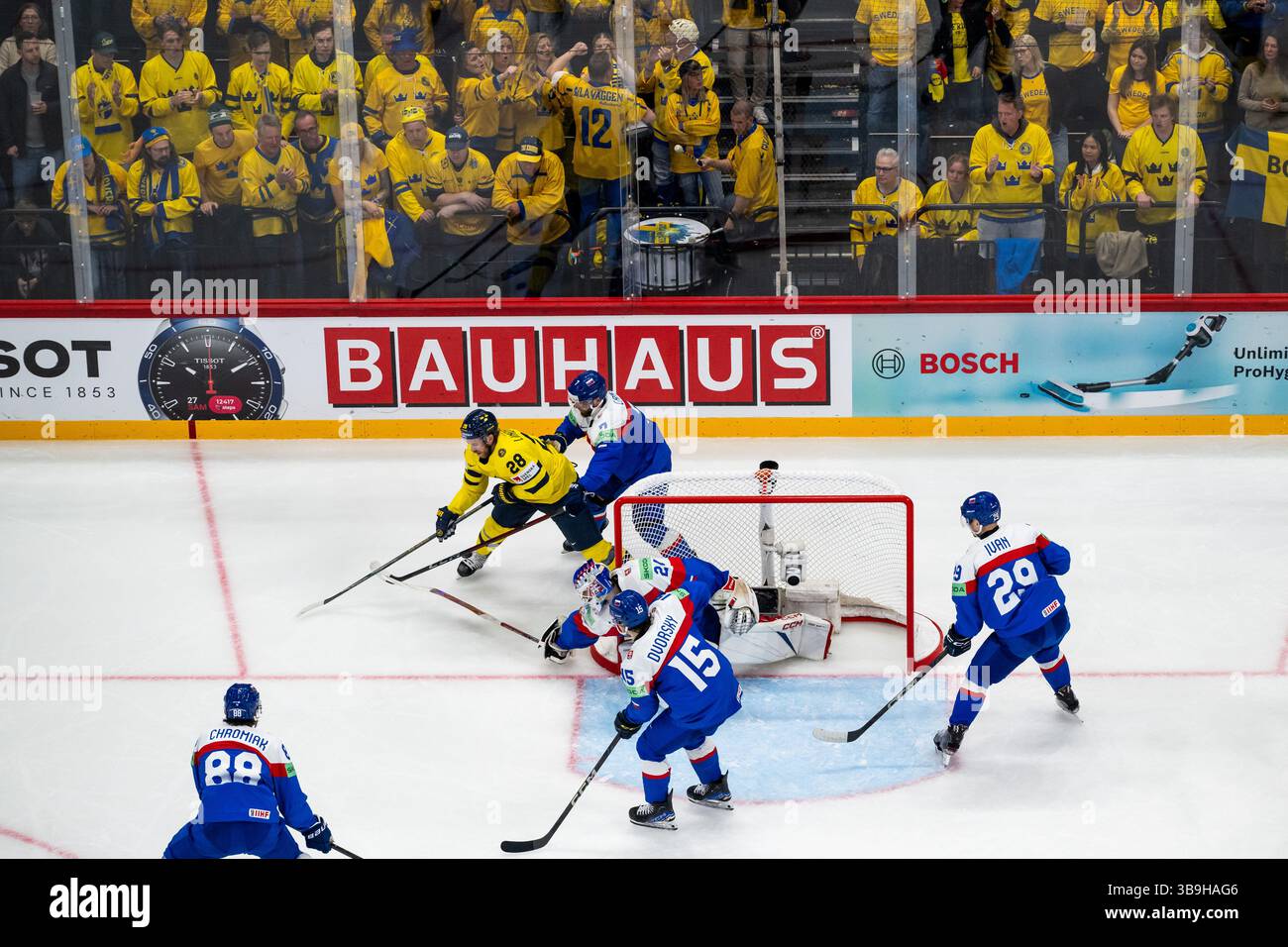 Elias Lindholm of, Sweden. , . competes for the puck with Mario Grman ...