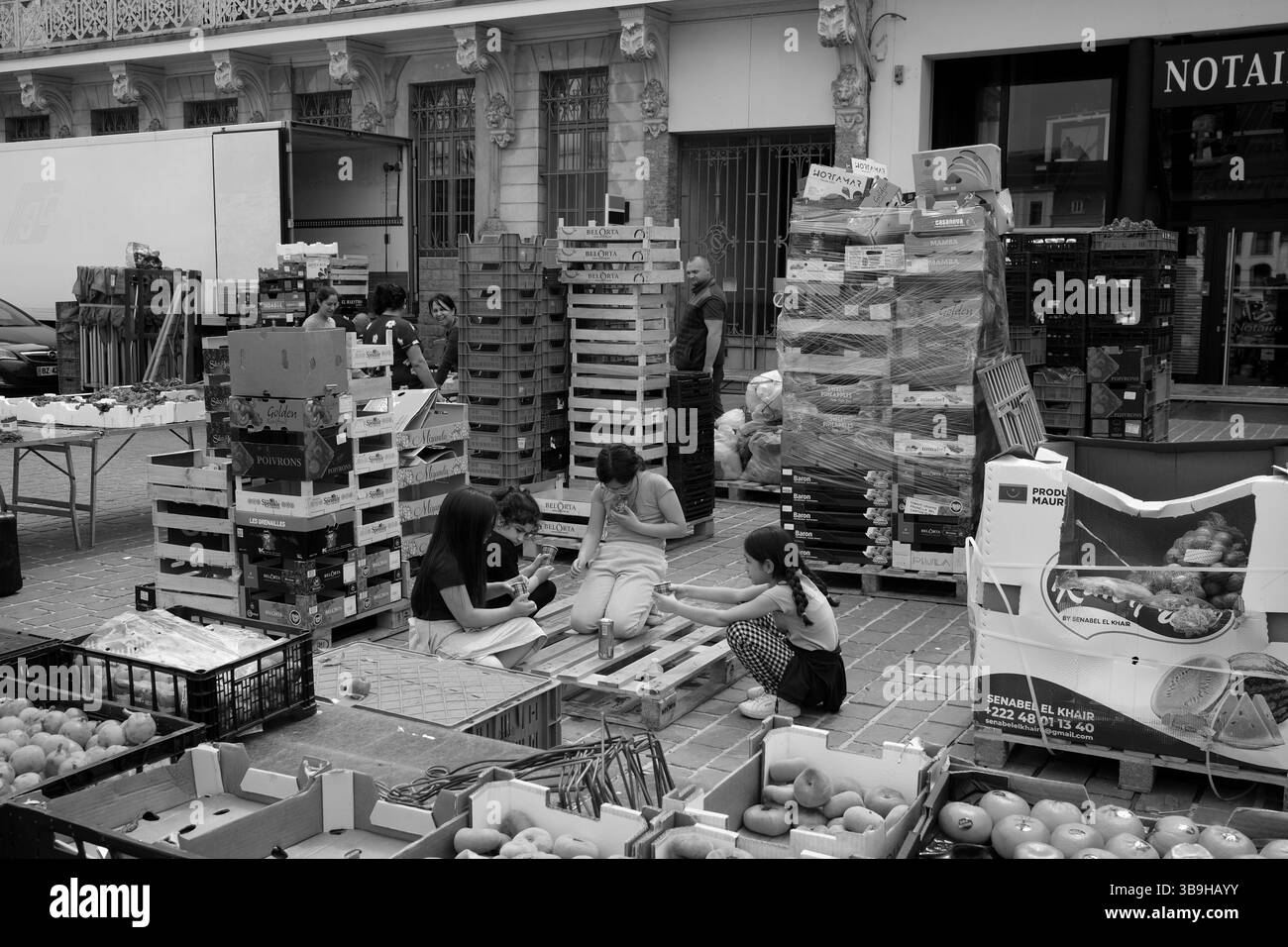 Children playing games while parents work at market stall in St Omer ...