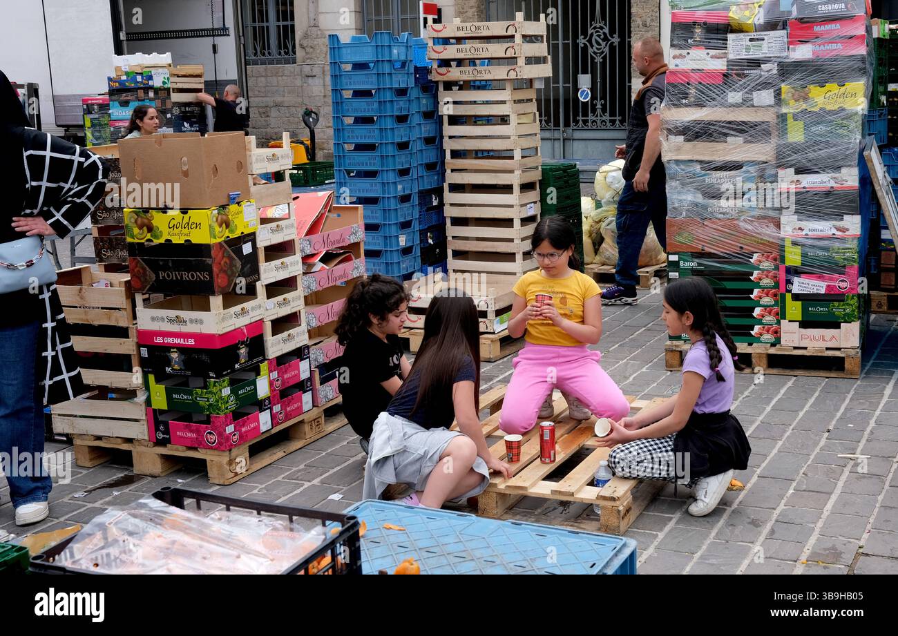 Children playing games while parents work at market stall in St Omer ...