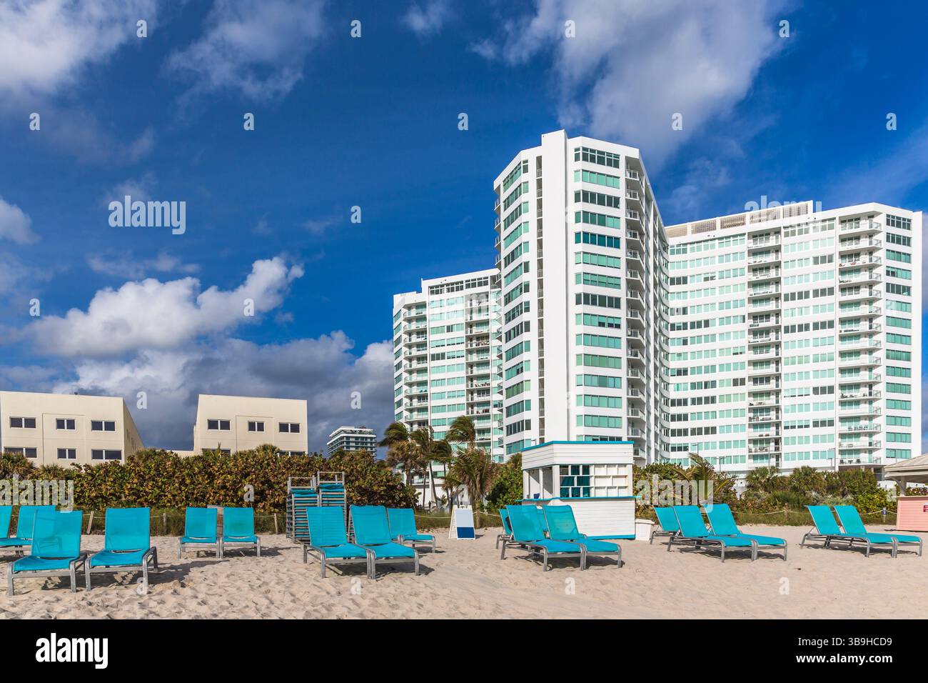 Beach with deck chairs, Burleigh House, high-rise building in Miami ...