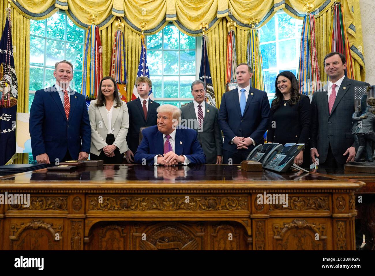 President Donald Trump speaks with reporters as he signs an executive ...