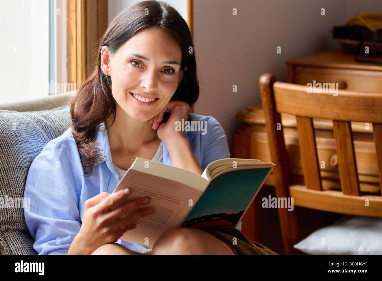 35-year-old woman at home, reading a book, looking at the camera Stock ...