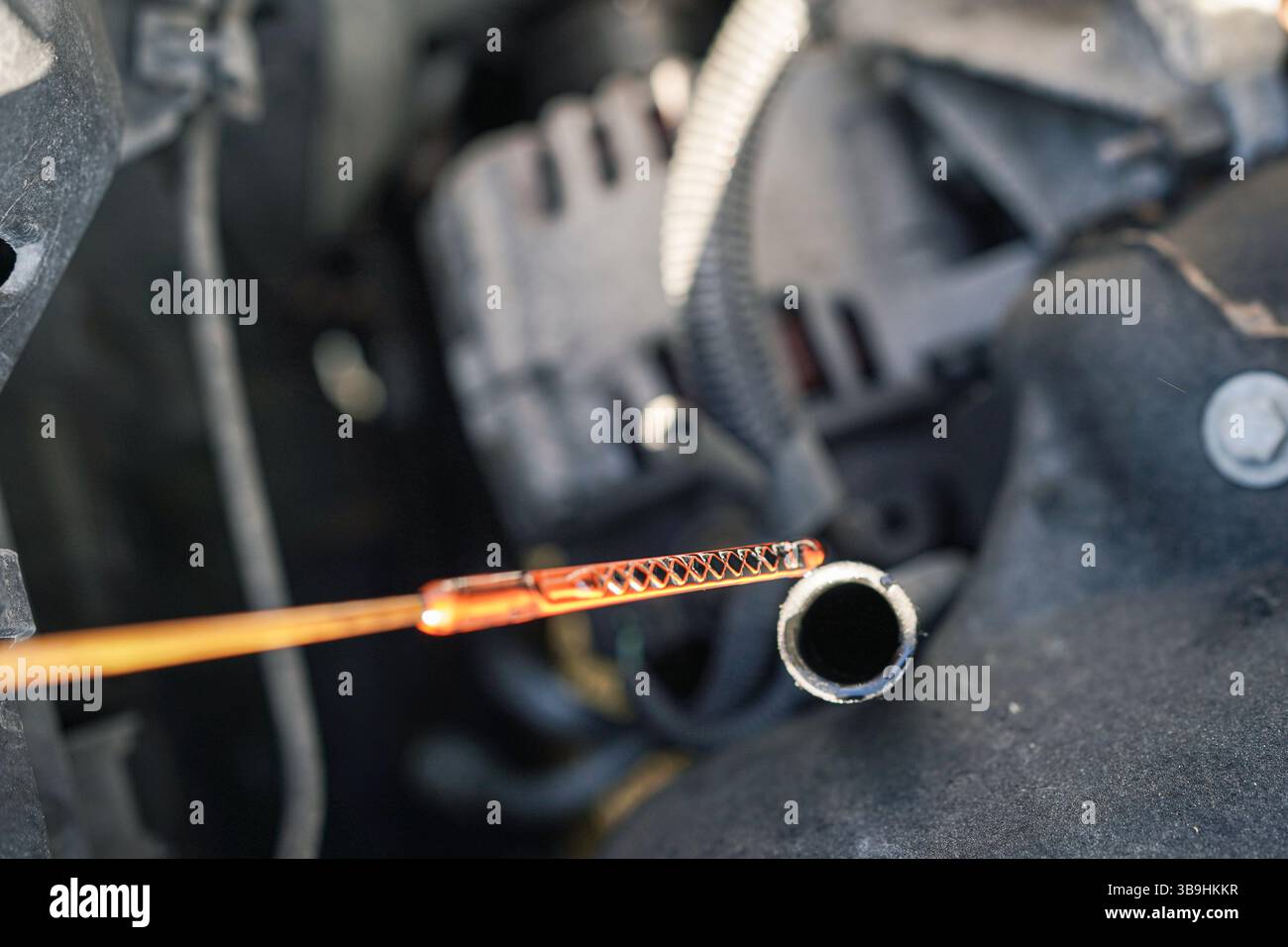 A car engine oil dipstick is being used to check the oil level Stock Photo - Alamy