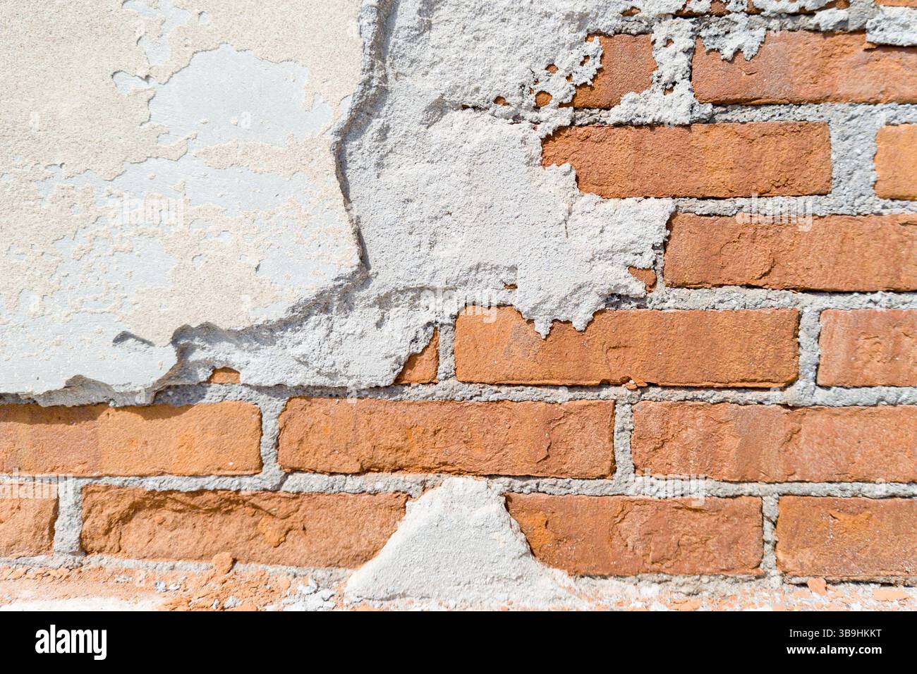 Exposed red brick wall with crumbling plaster Stock Photo - Alamy