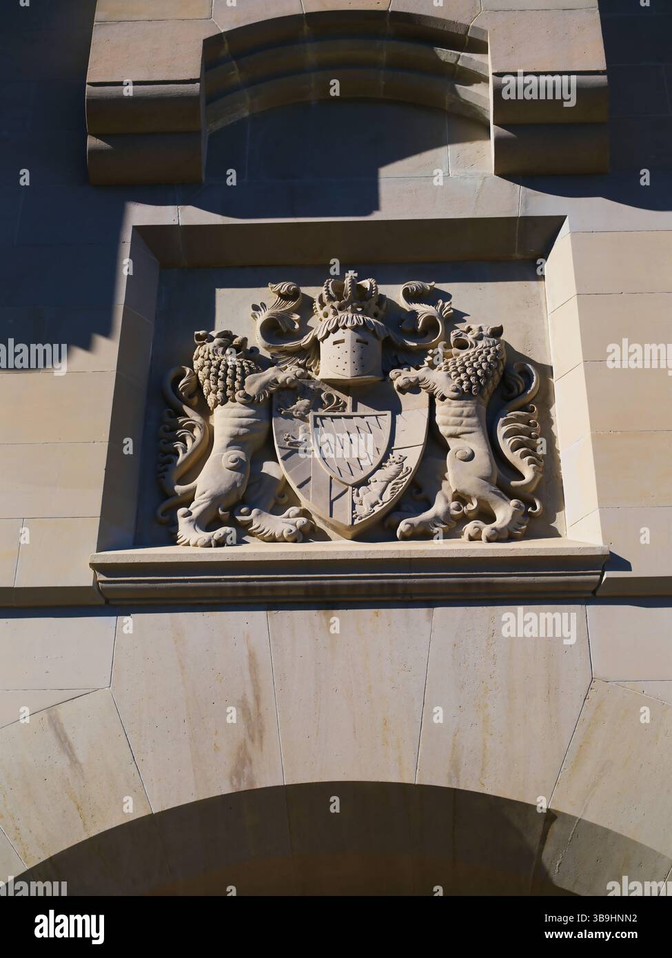 Historic stone emblem featuring lions and a shield displayed on a ...