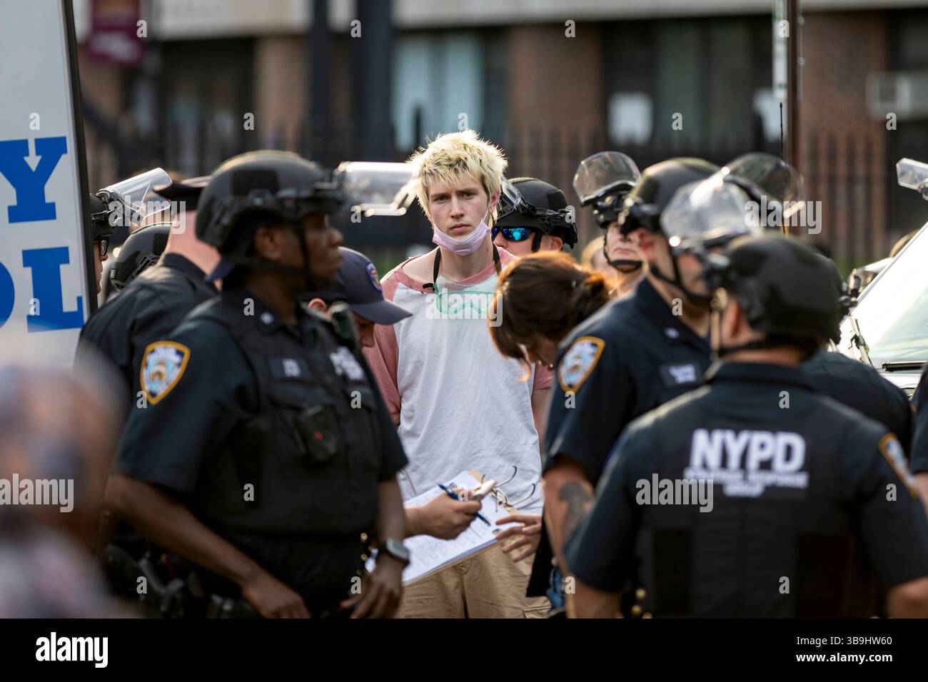 A ?handcuffed protester ?waits to enter a police vehicle after being ...