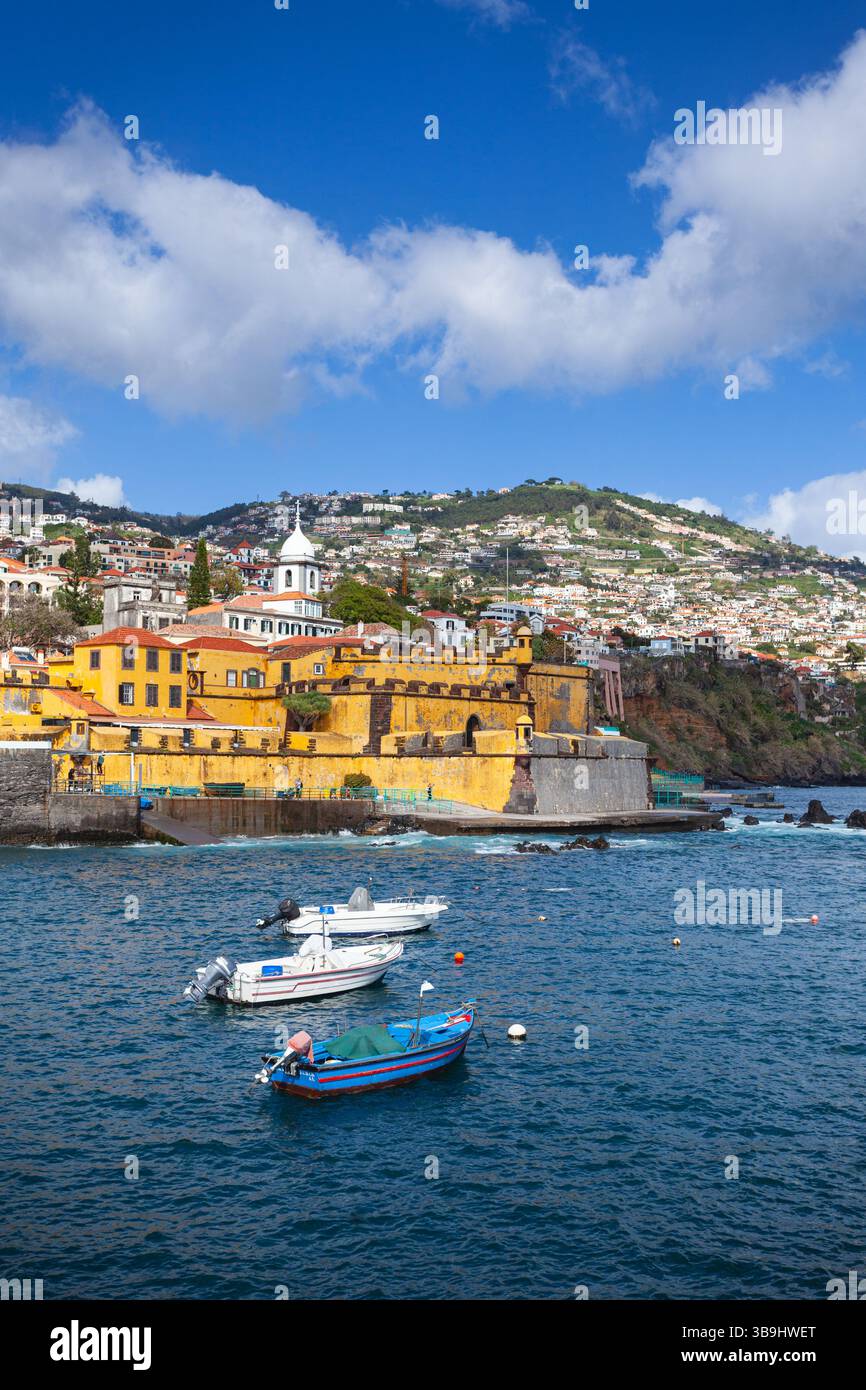 Small boats moored in front of the Fortress of São Tiago, the iconic ...