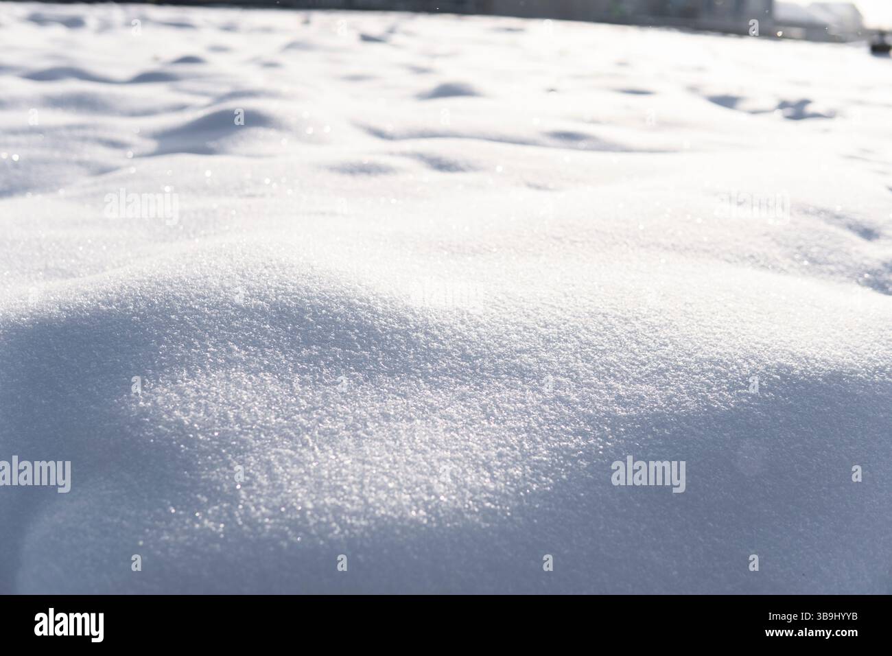 Textured snow mounds sparkling in daylight, forming natural curves and ...