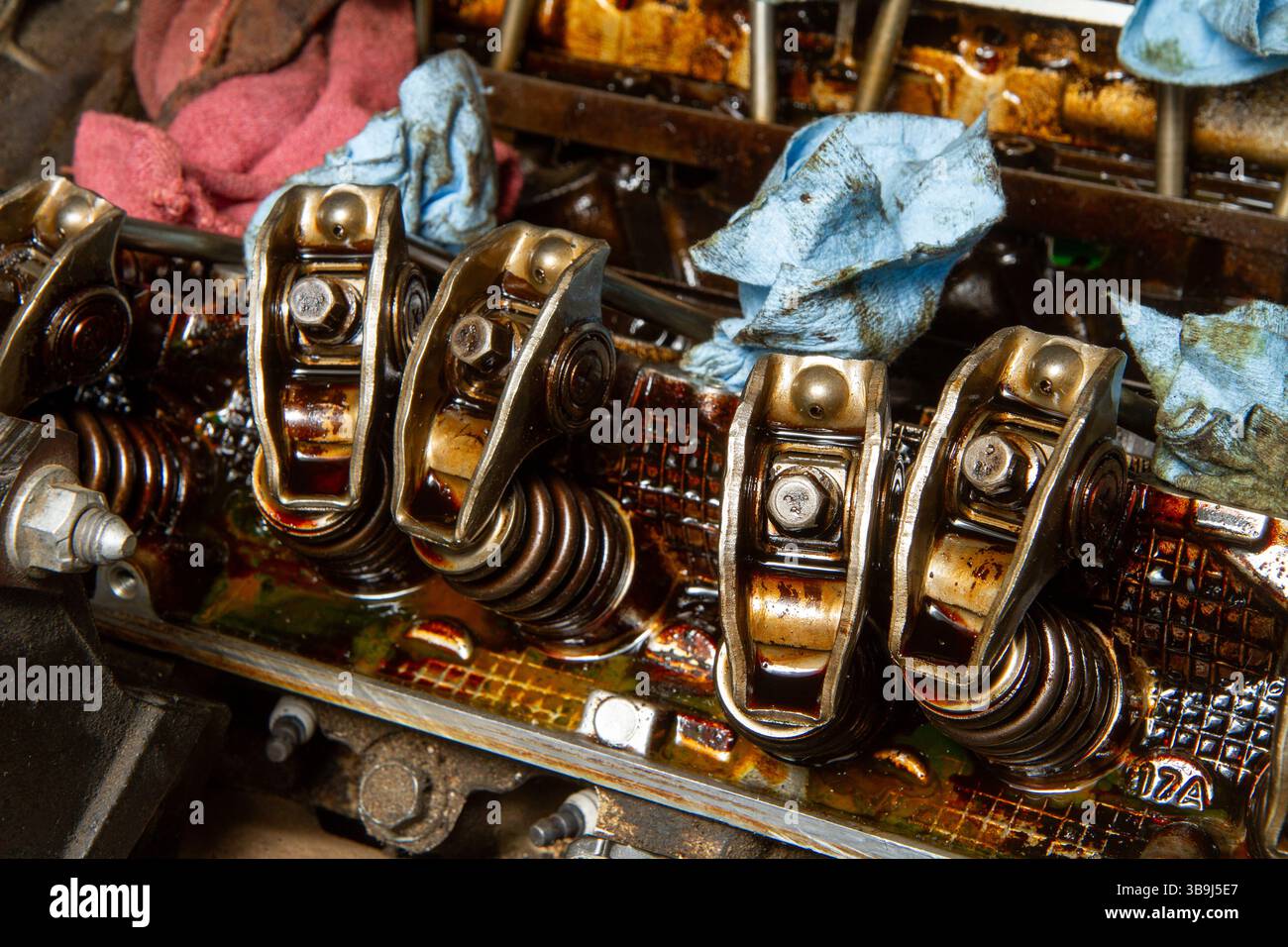 A close up of the engine of a car with the oil and grease visible. The ...