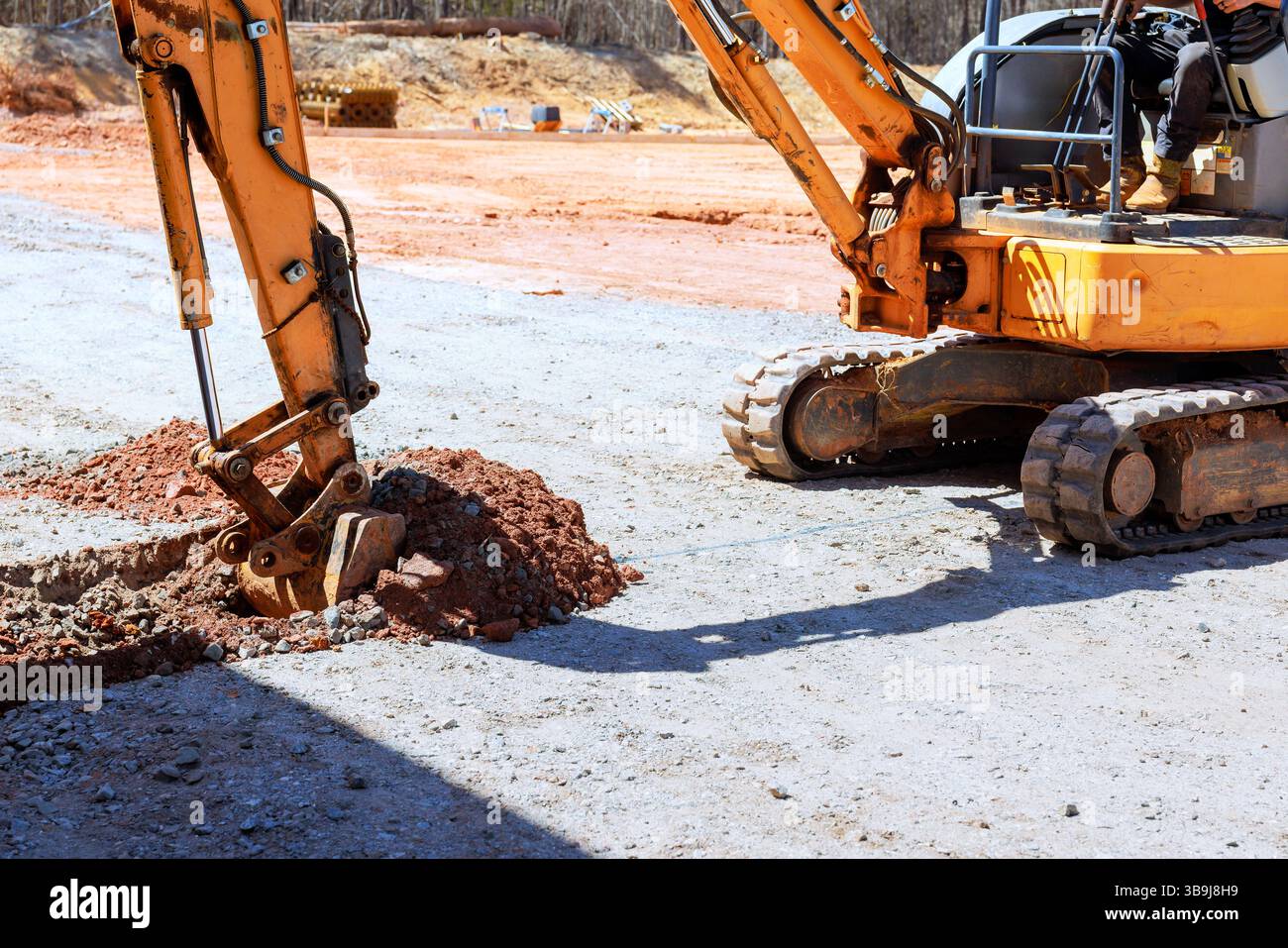 Heavy machinery is digging into ground at construction site during ...