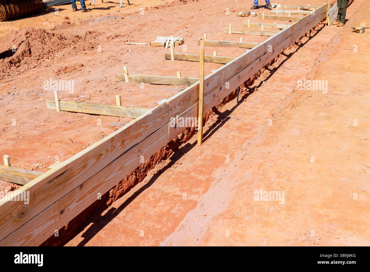 Worker are laying wooden forms for foundation at construction site ...
