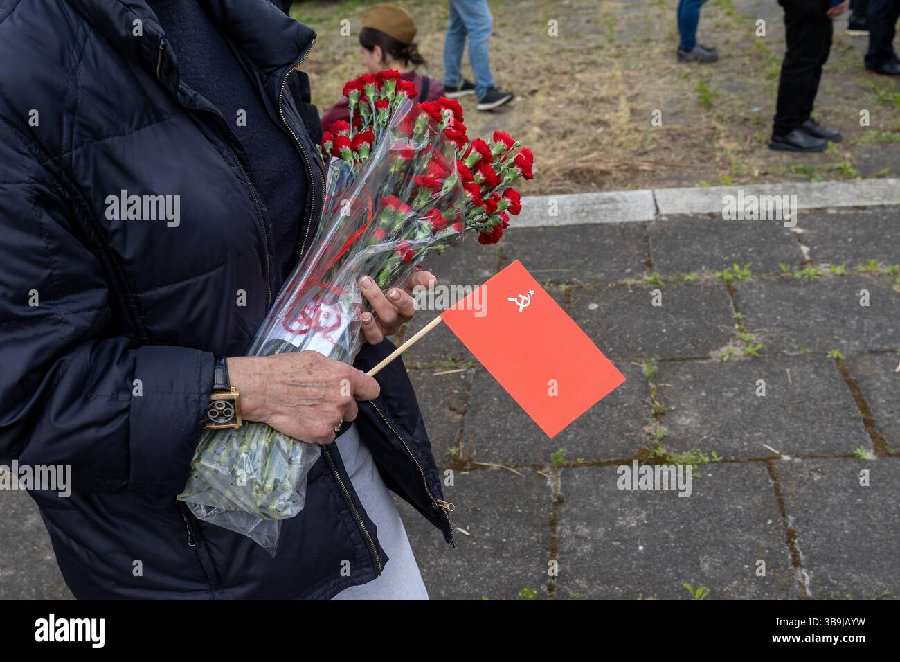 A protester holds red flowers and a Soviet Union flag at the Soviet ...