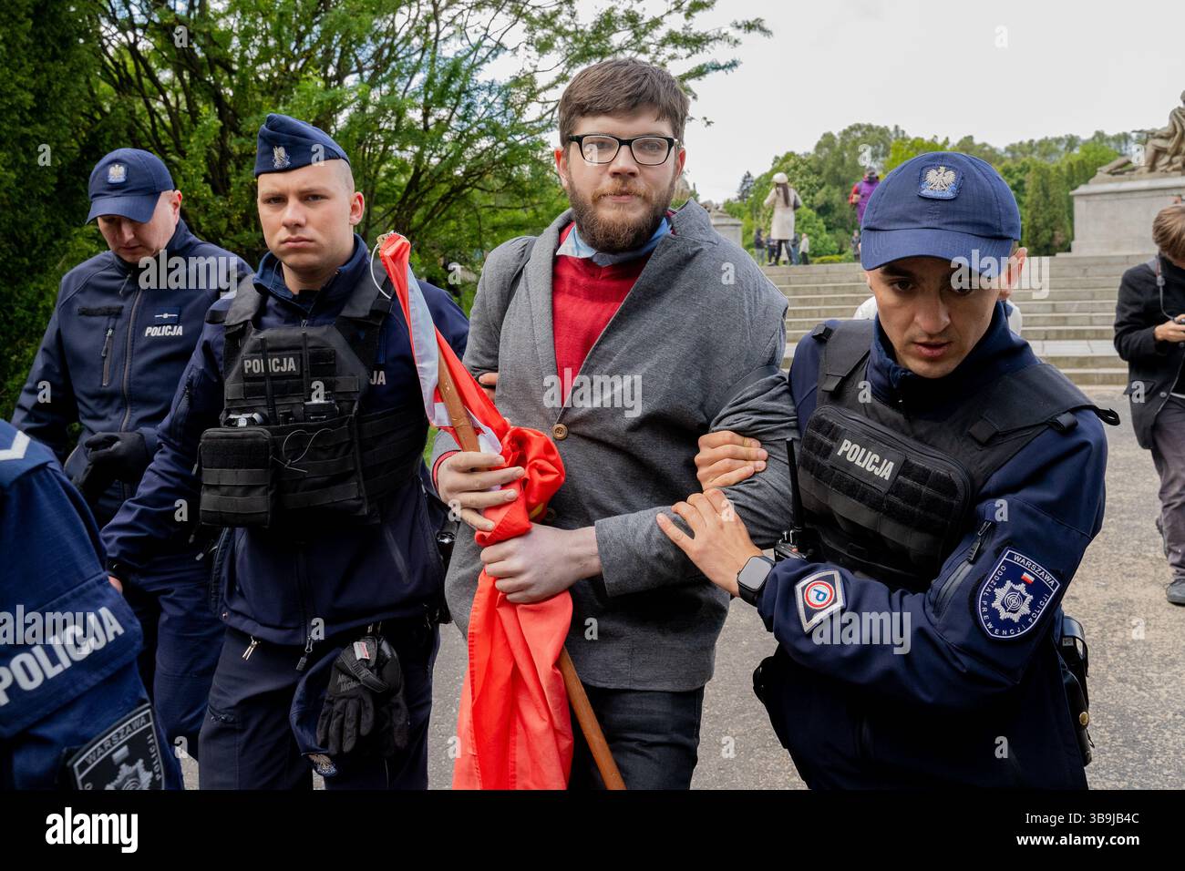 A protester is detained by police for waving a Soviet Union flag during ...