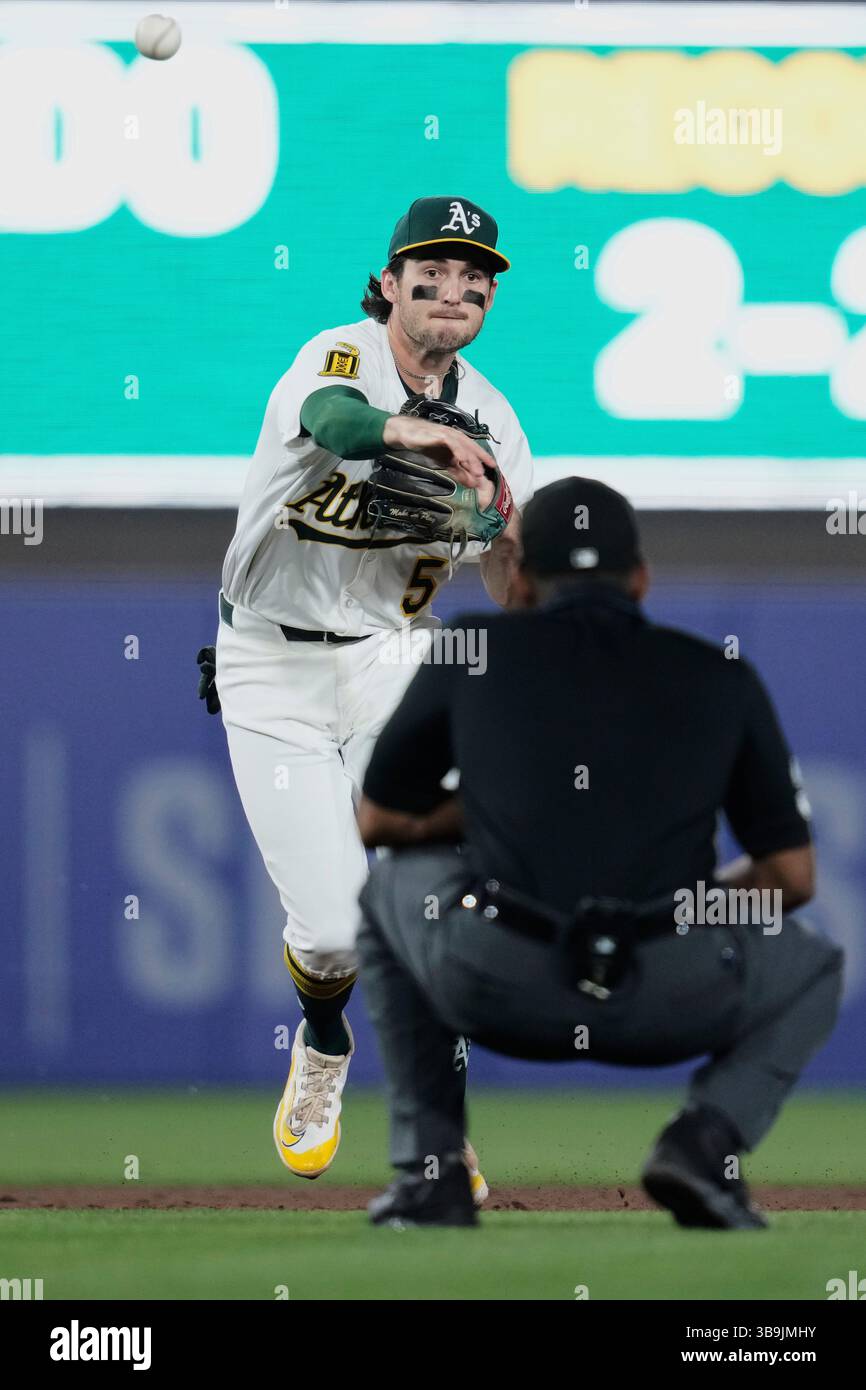 Athletics shortstop Jacob Wilson (5) throws to first for an out on New ...