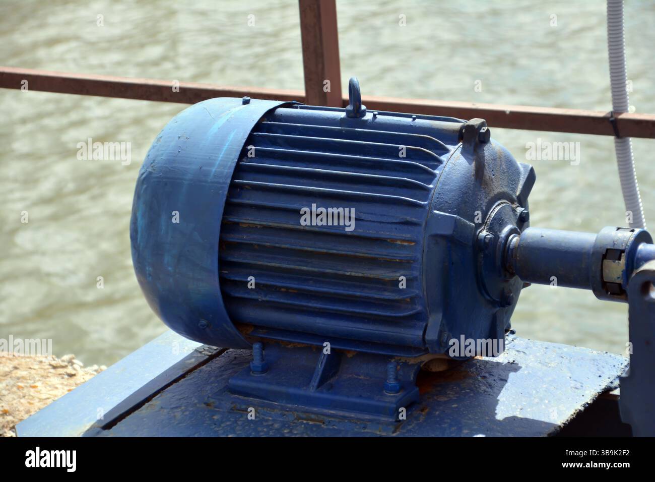 The blue motor of the water pump on the river, close-up. Water pump in ...