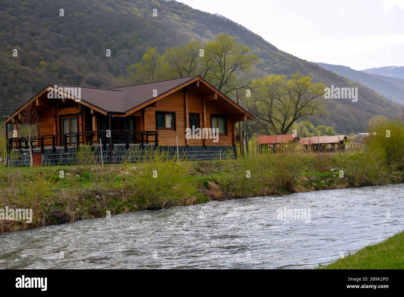 Wooden cottage on the river bank. House in nature. Hotel in the forest ...