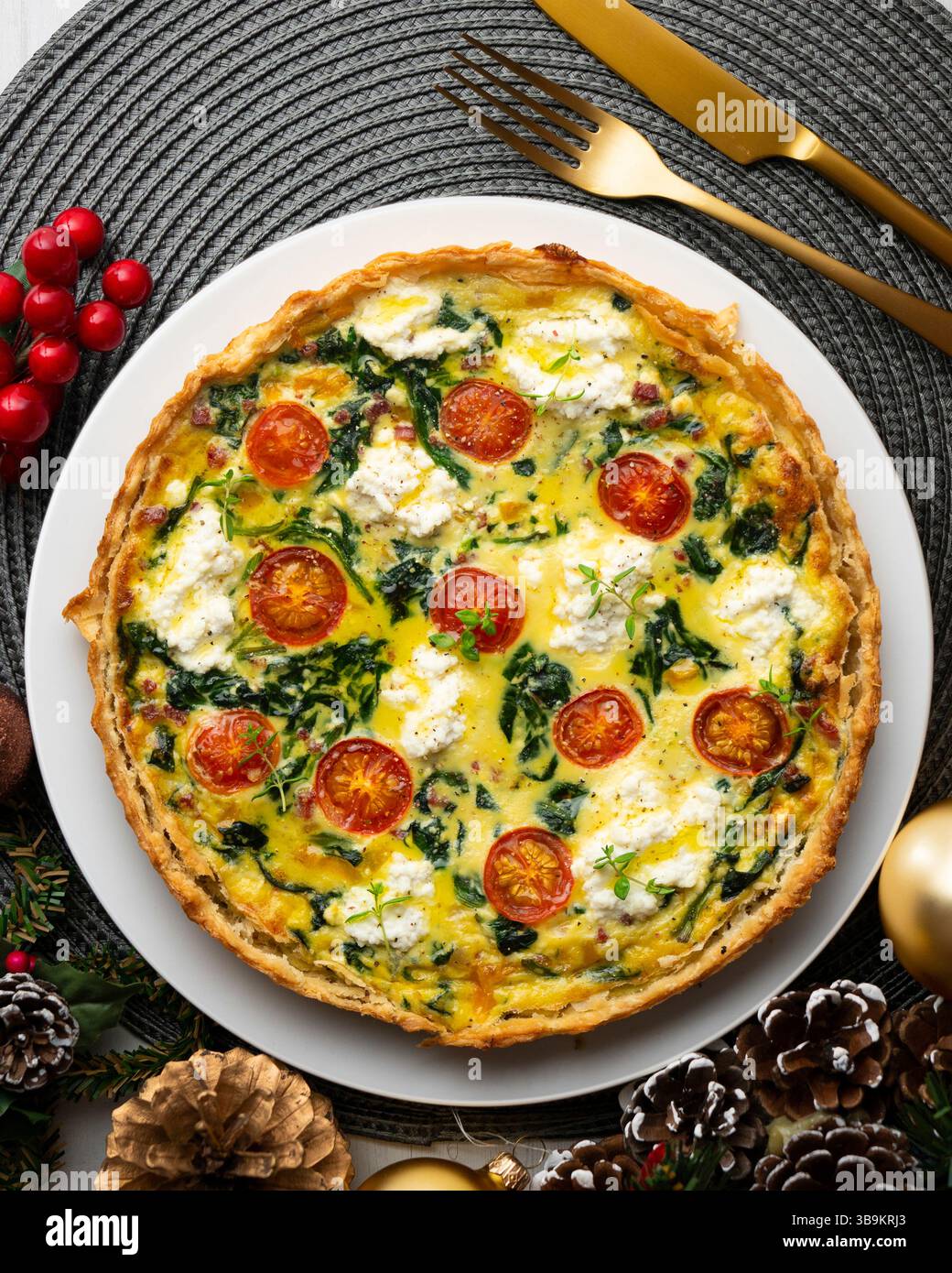 French quiche with spinach, cheese, tomatoes, and diced ham. Top view ...