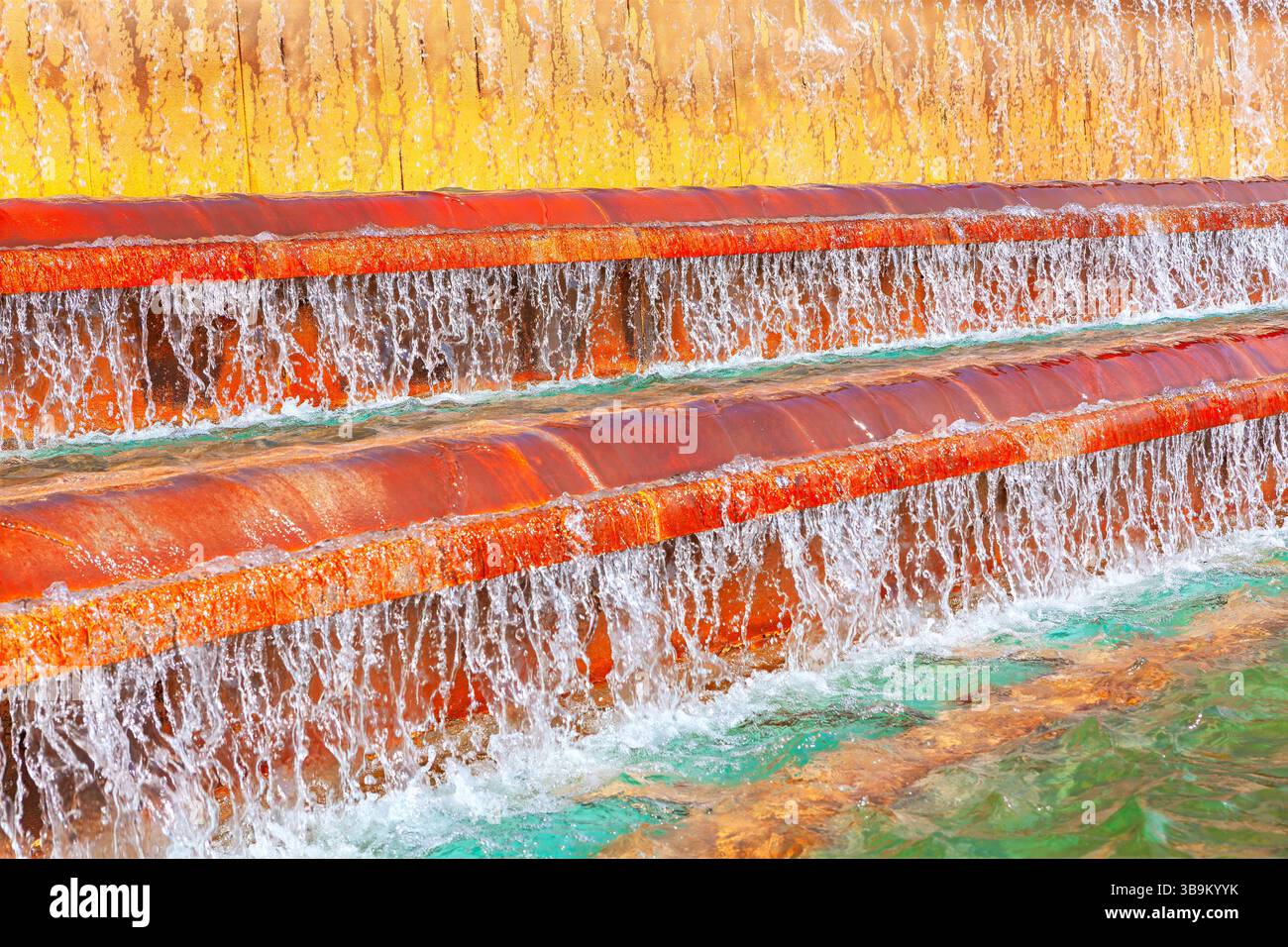Cascading water flows down tiered channels. Tiered fountain design ...