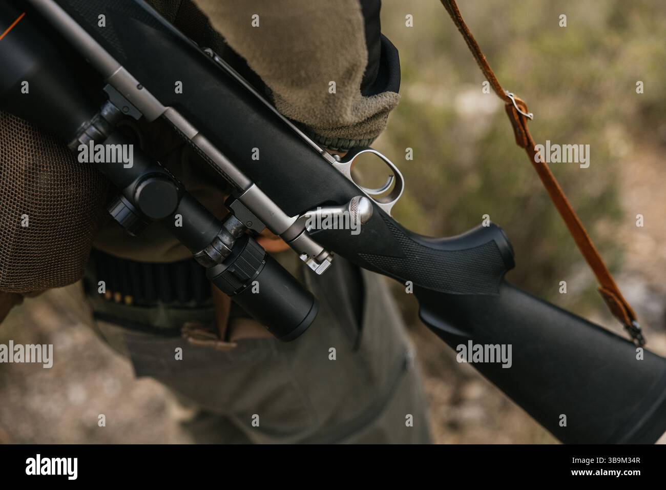 Hunter holding rifle with scope in nature Stock Photo - Alamy
