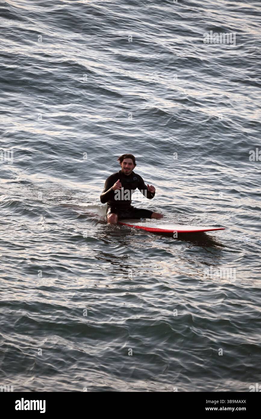 A surfer shows his enthusiasm while waiting for a wave on the Outer ...