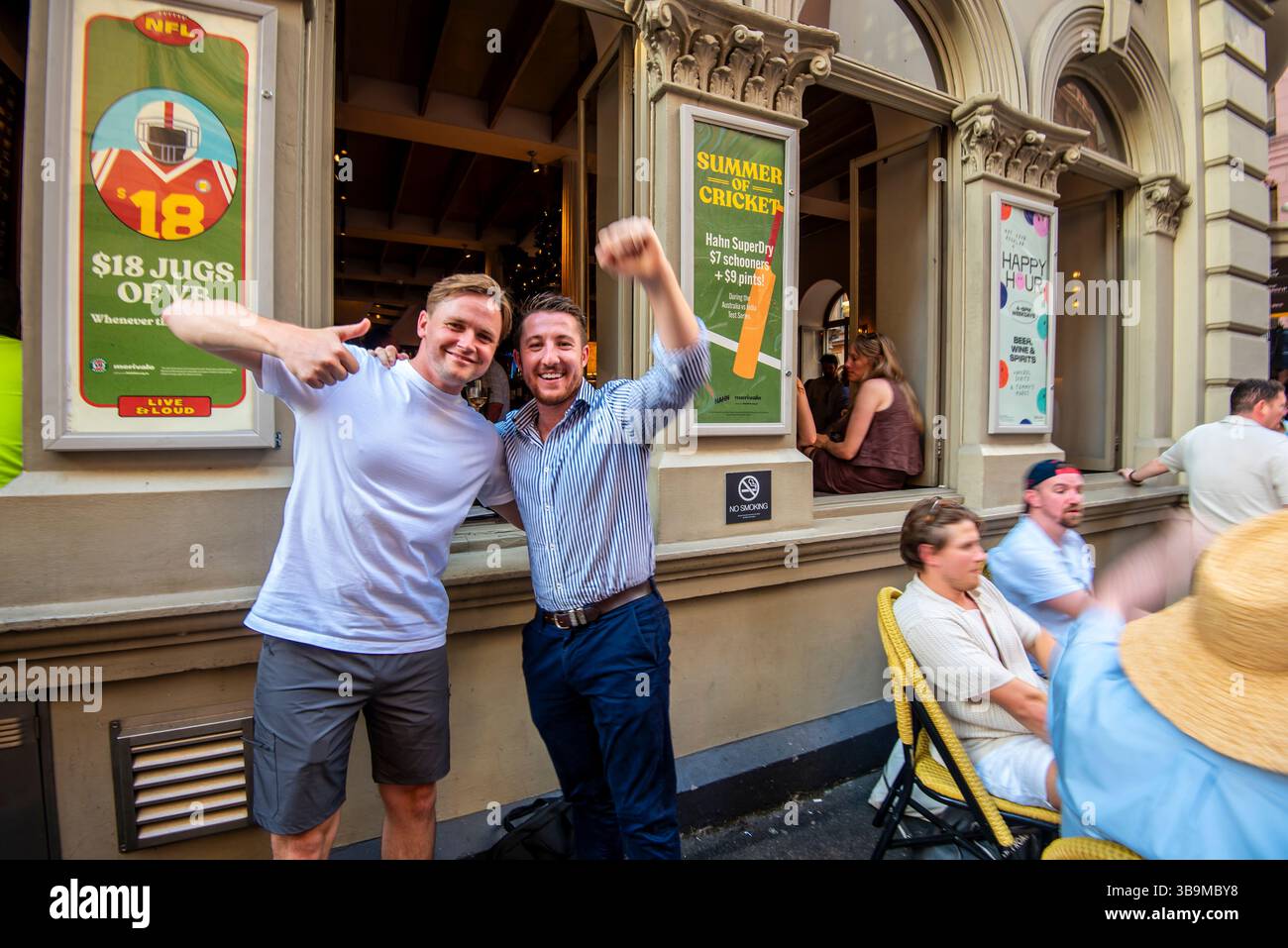 Two young men giving the thumbs up and a fist pump as they celebrate ...